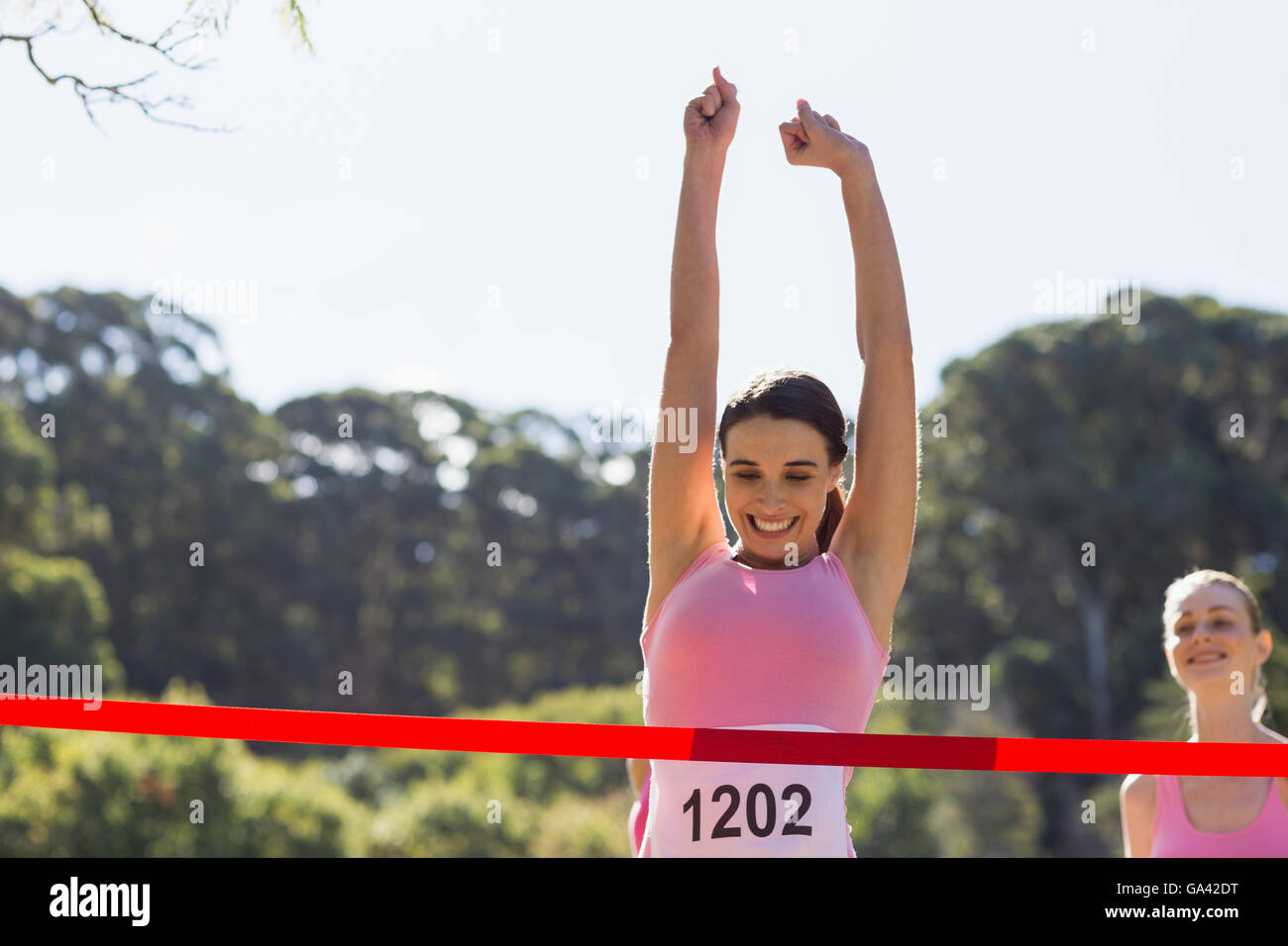 Cheerful winner athlete crossing finish line Stock Photo - Alamy