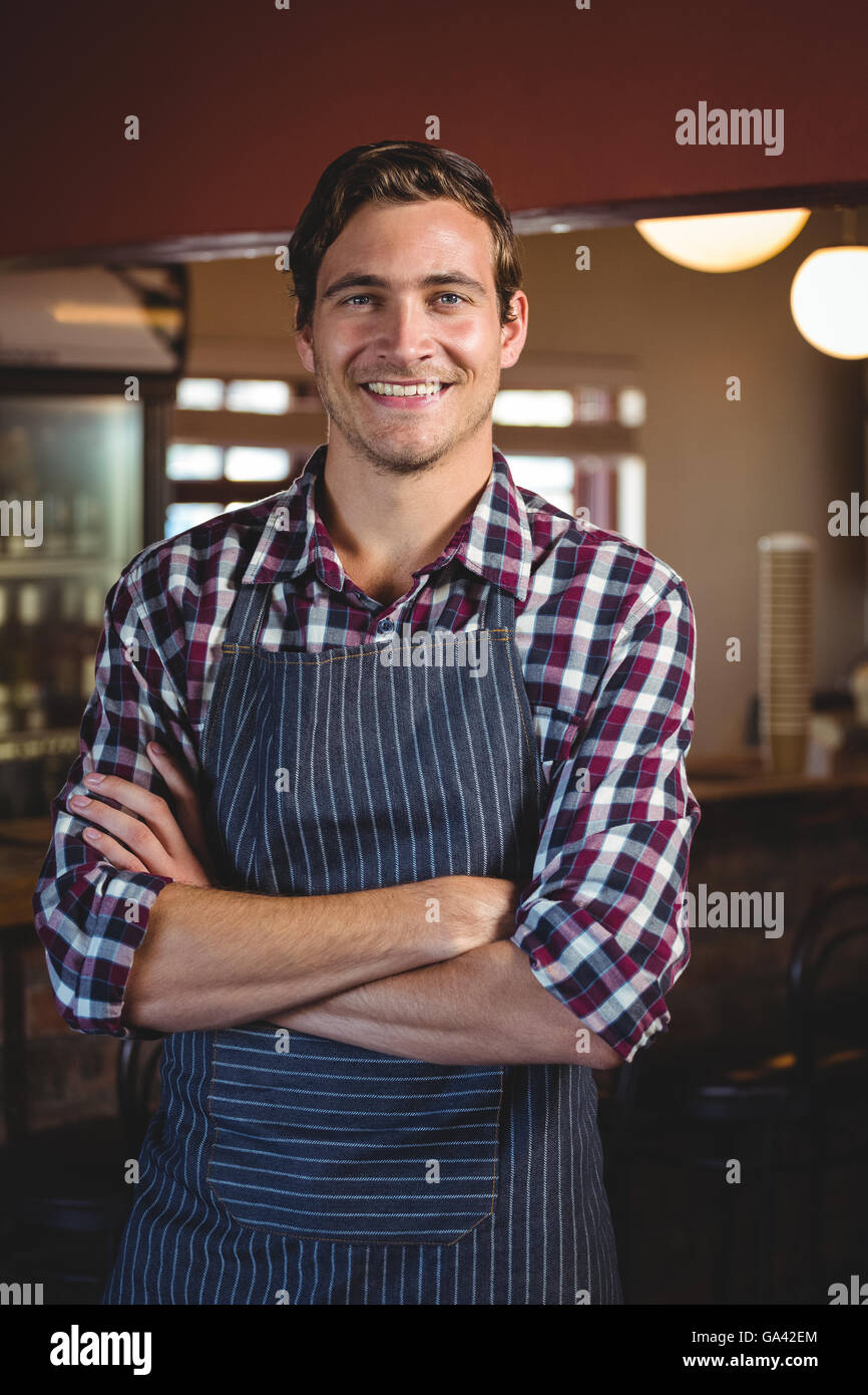 Portrait of smiling waiter standing with arms crossed Stock Photo - Alamy