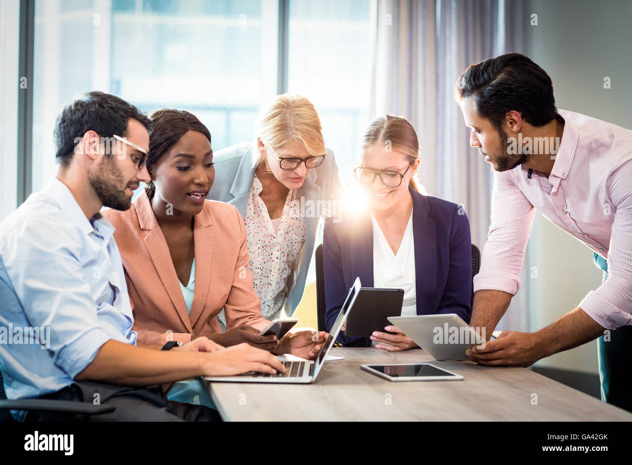Business people interacting using laptop, mobile phone and digital ...