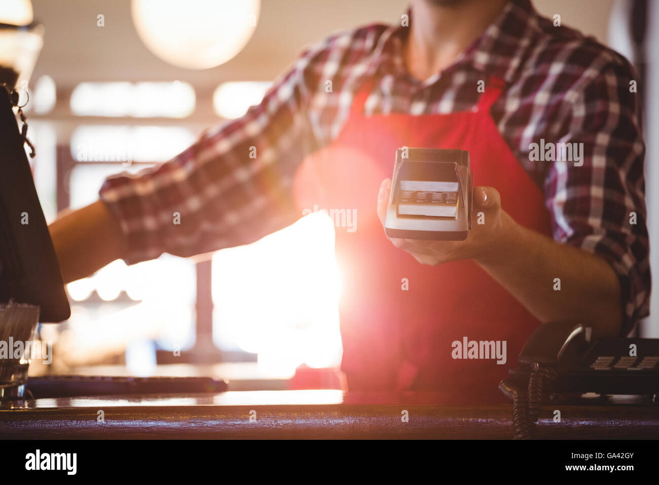 Mid section of waiter showing credit card machine Stock Photo - Alamy