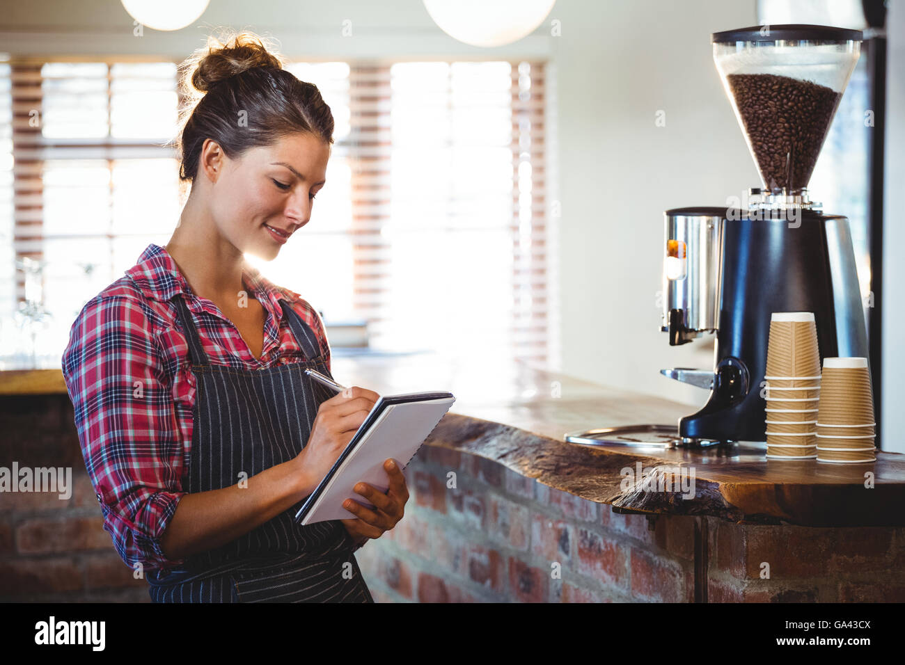 Waitress writing in a book Stock Photo - Alamy