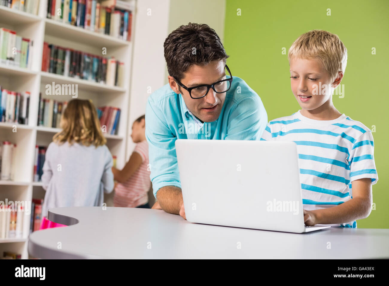 Schoolboy using computer teacher hi-res stock photography and images ...