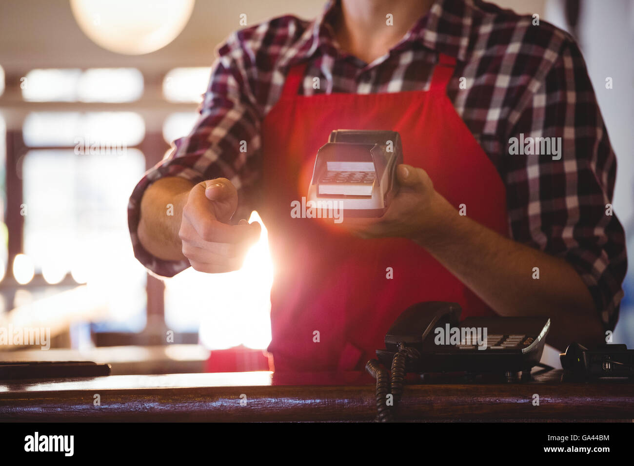 Mid section of waiter showing credit card machine Stock Photo - Alamy