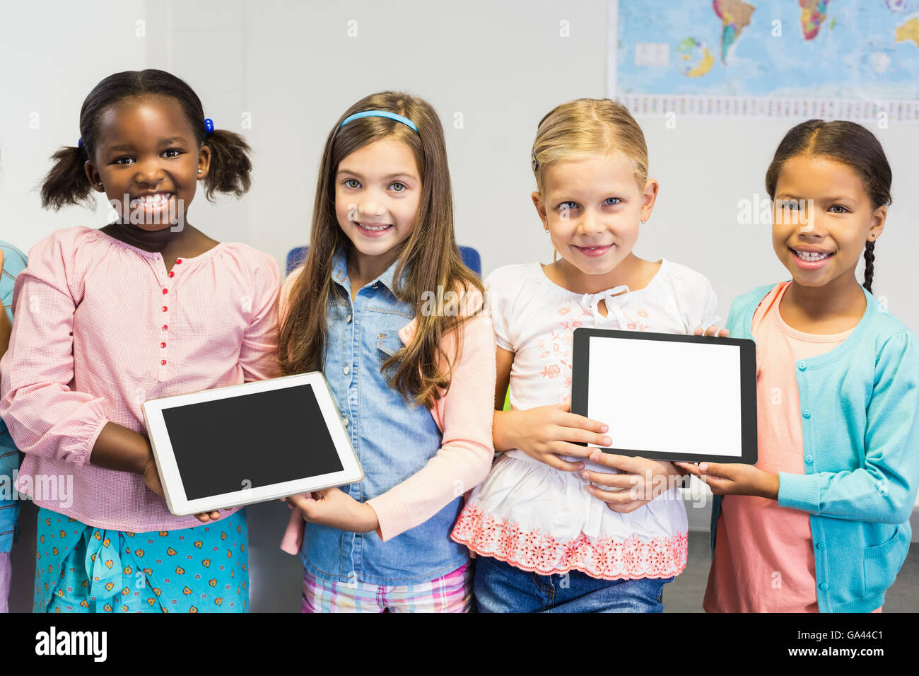 Portrait of students holding digital tablet in classroom Stock Photo ...