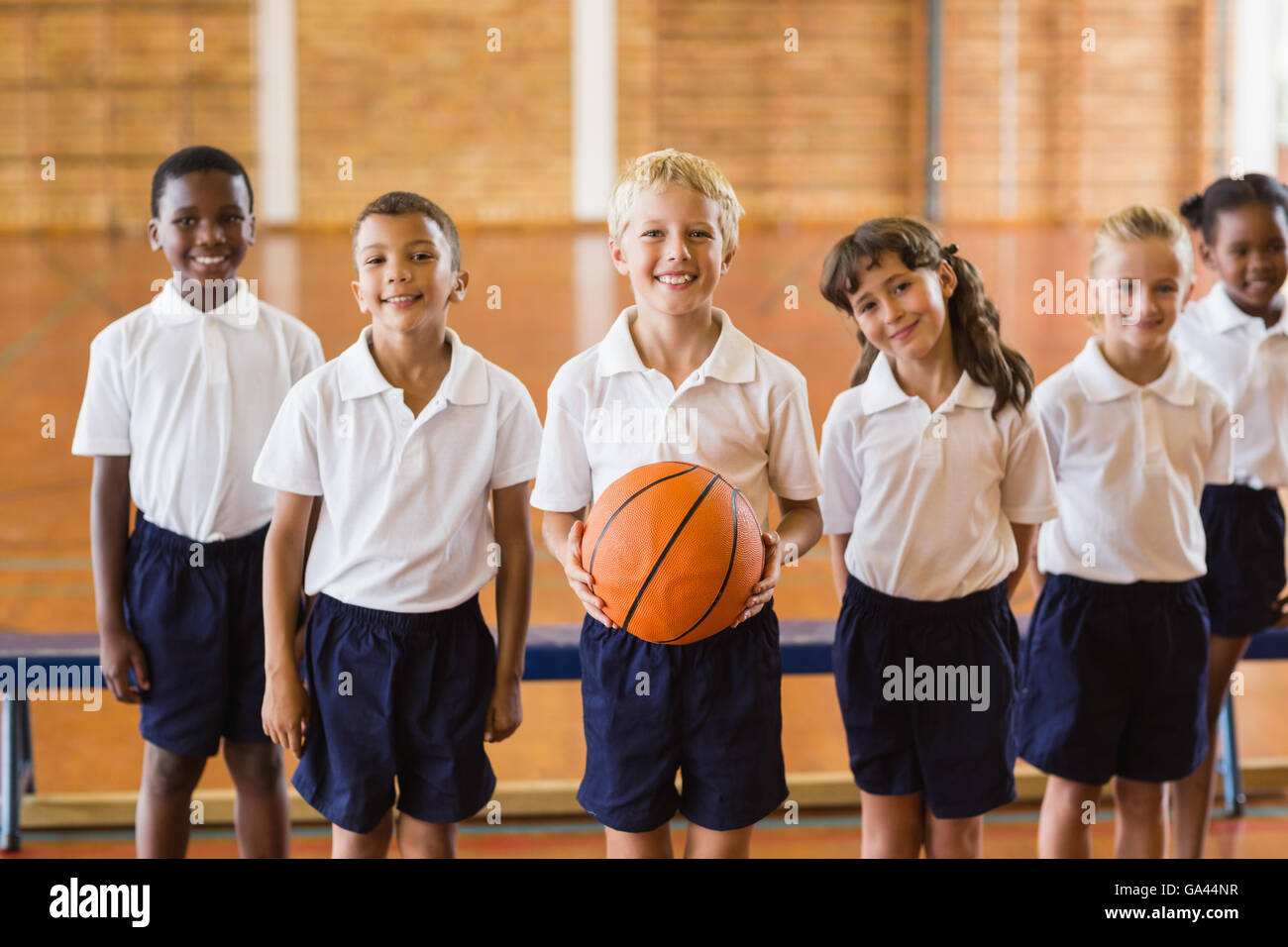 Smiling students standing with basketball Stock Photo - Alamy