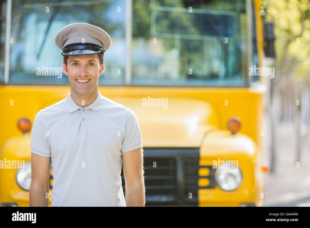 Bus driver smiling in front of bus Stock Photo - Alamy