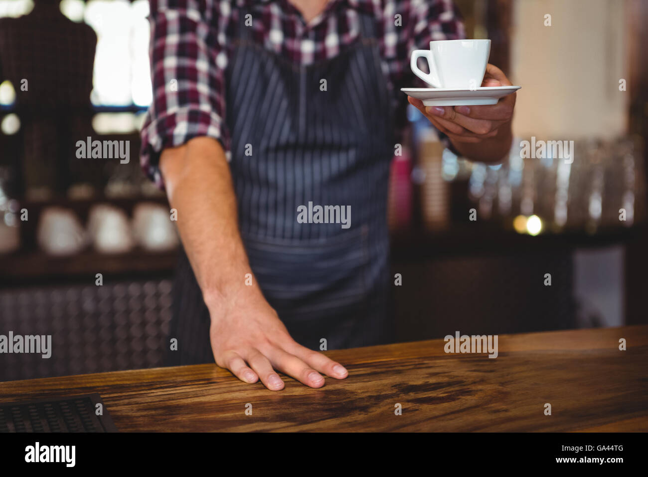 Waiter handing over a coffee Stock Photo - Alamy