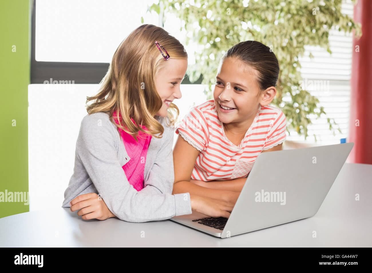 Kids using laptop in library Stock Photo - Alamy