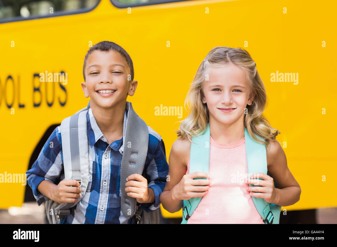 Smiling kids standing in front of school bus Stock Photo - Alamy