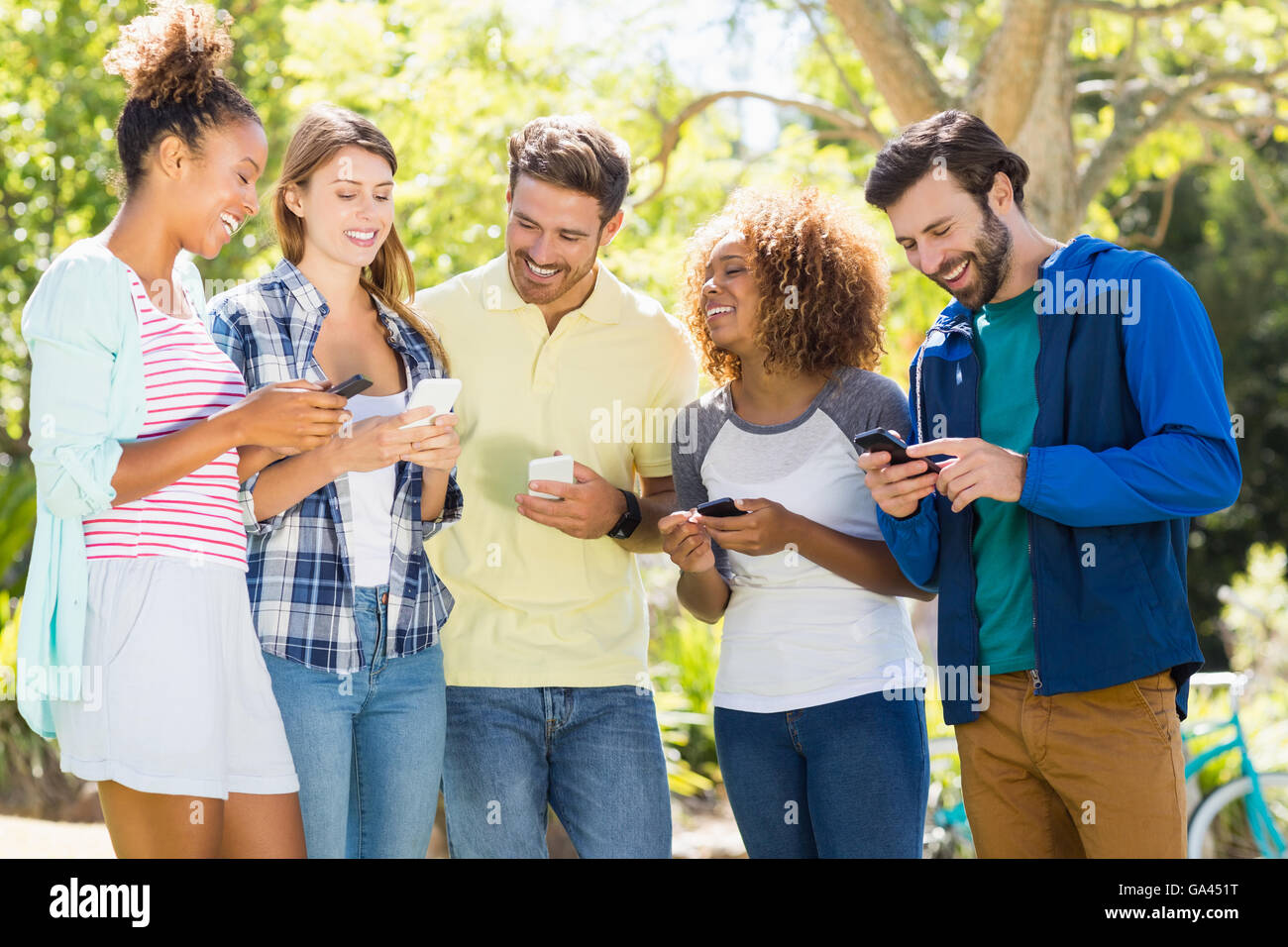 Group of friends using mobile phone Stock Photo - Alamy