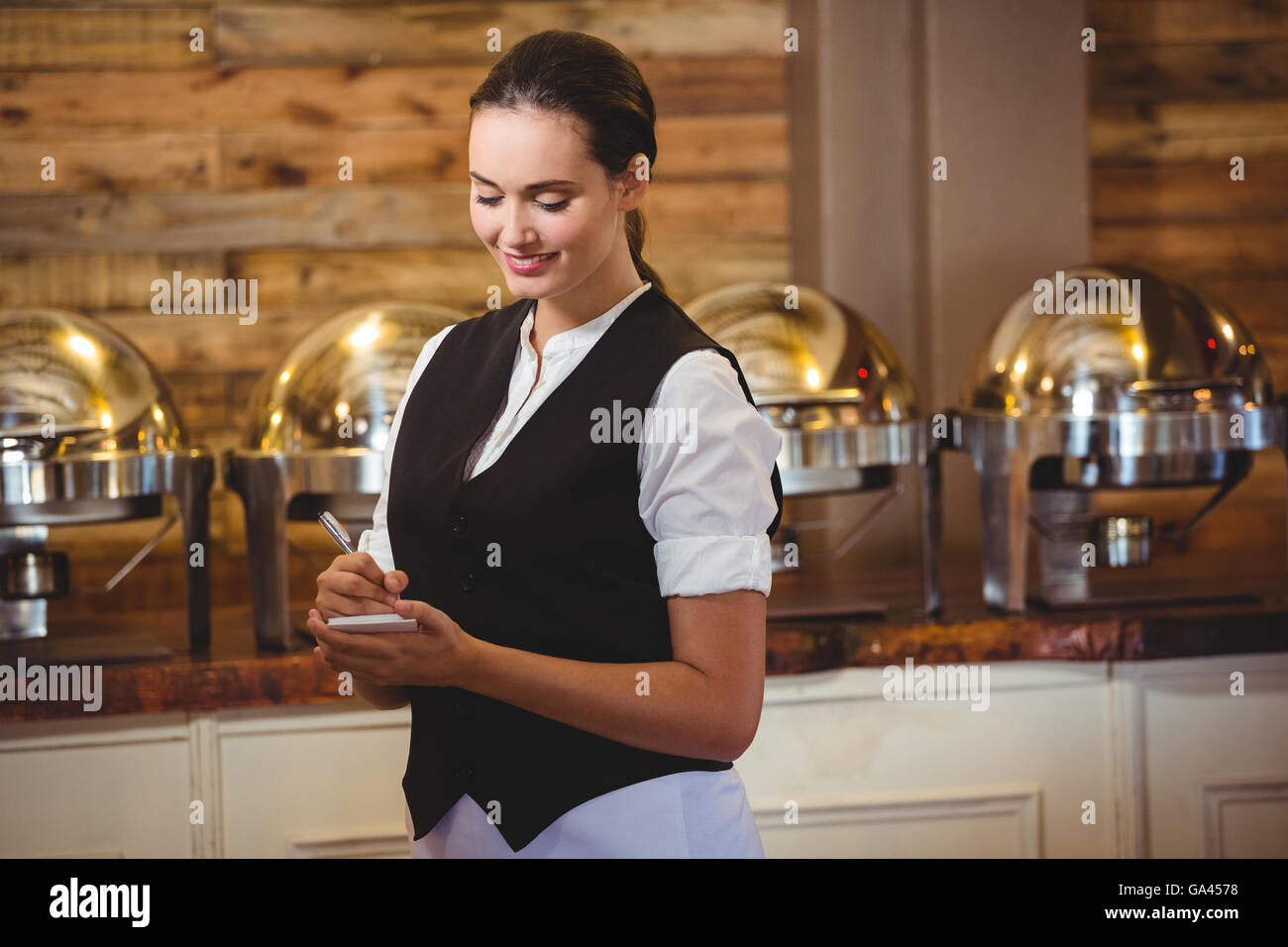 Waitress taking order on a notebook Stock Photo - Alamy