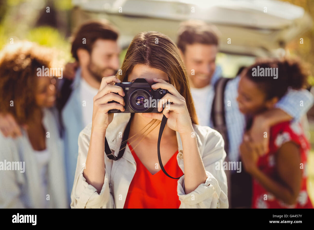 Woman clicking a photo from camera in park Stock Photo - Alamy
