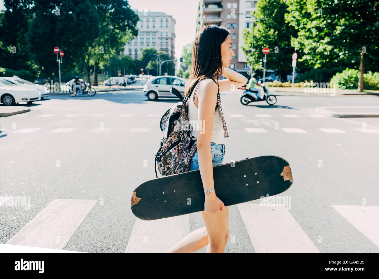 Knee figure of young beautiful asiatic woman skater walking outdoor in ...