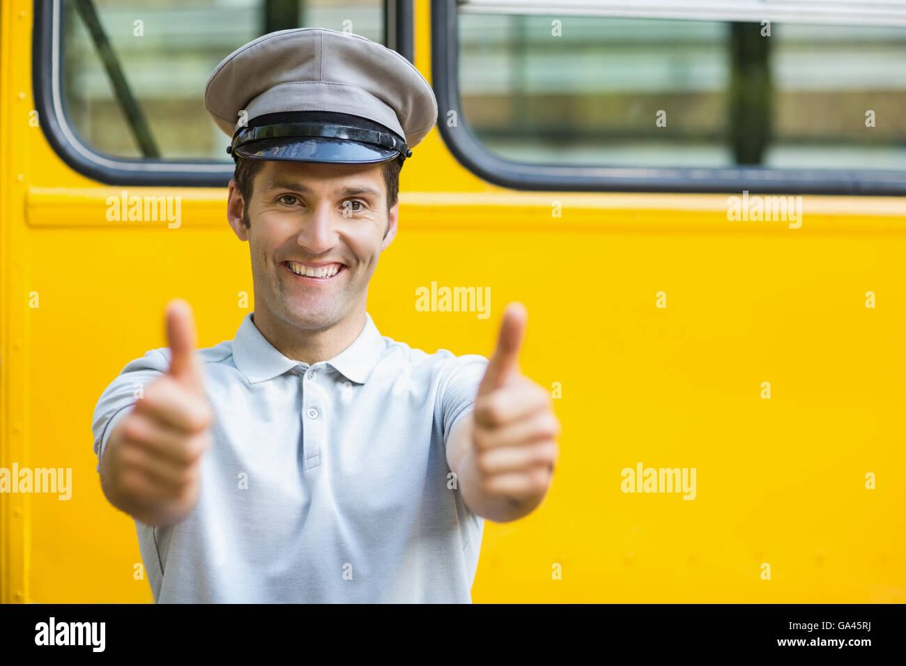 Smiling bus driver showing thumbs up in front of bus Stock Photo - Alamy