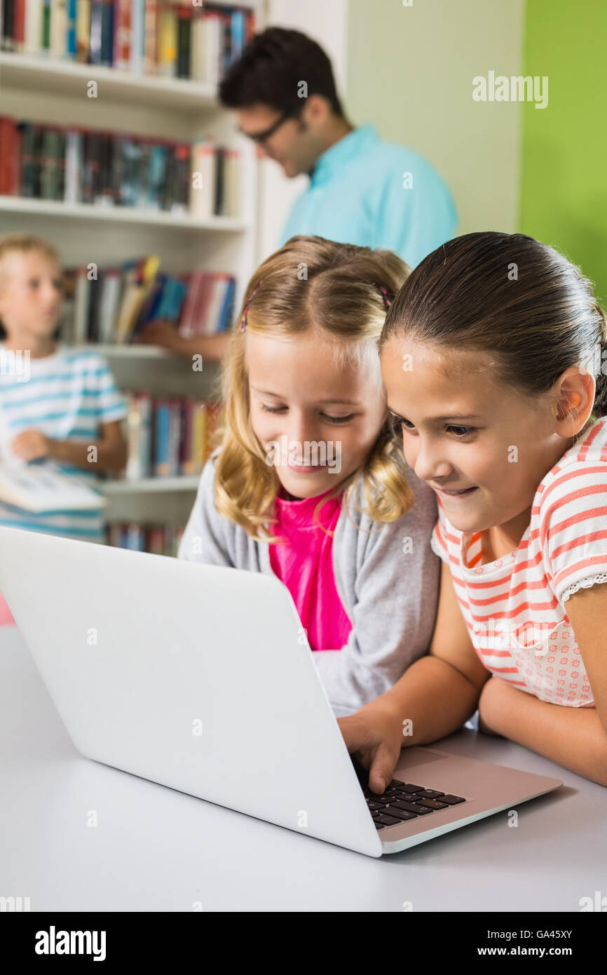 Kids using laptop in library Stock Photo - Alamy