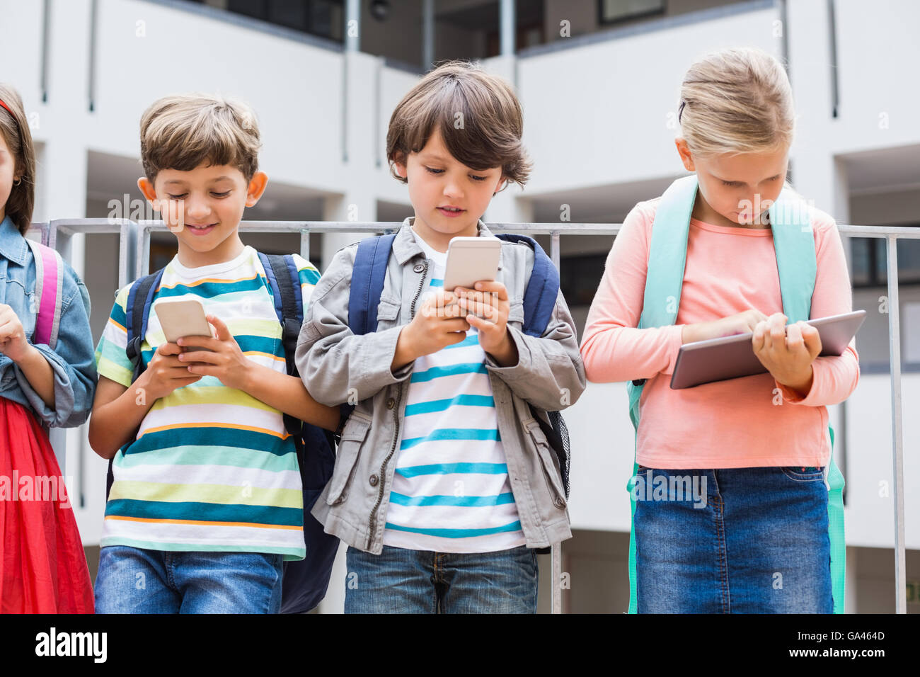 Kids using mobile phone and digital tablet on school terrace Stock ...