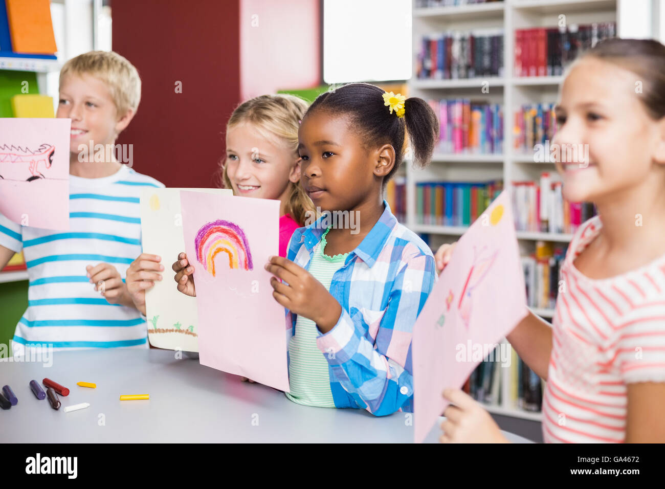 Kids showing drawing in library Stock Photo - Alamy