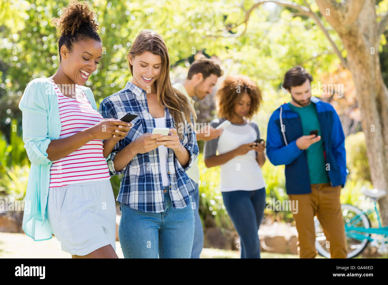 Group of friends using mobile phone Stock Photo - Alamy