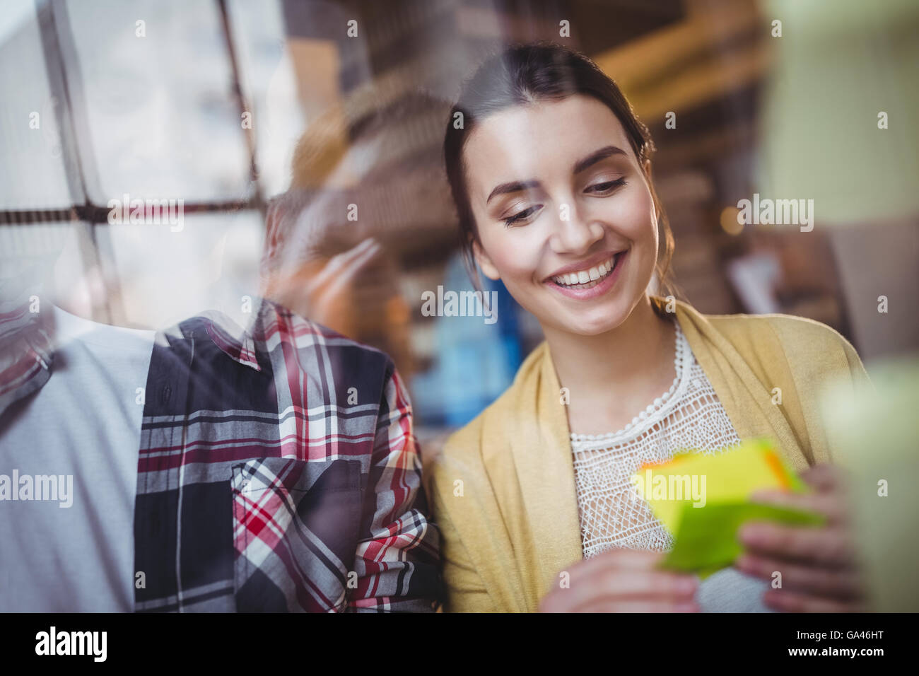 Businesswoman smiling while reading sticky notes Stock Photo - Alamy