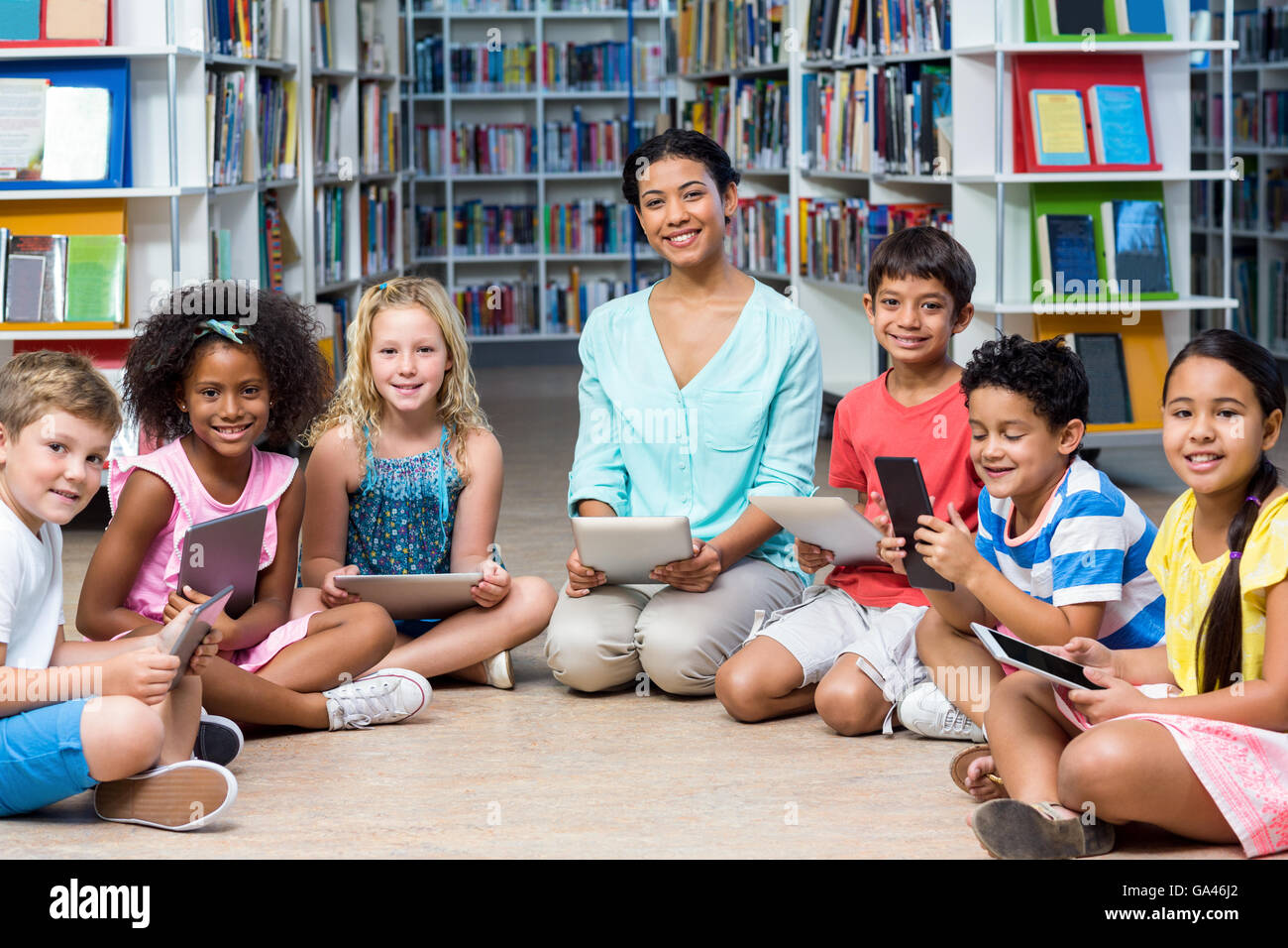 Teacher with children holding digital tablets Stock Photo - Alamy