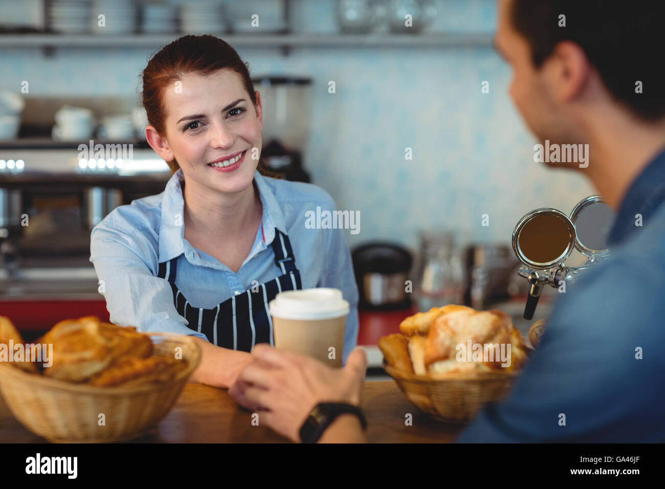 Portrait of happy barista giving coffee to customer at cafe Stock Photo ...