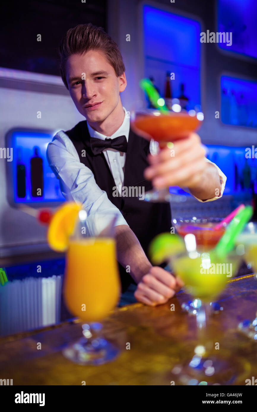 Portrait of smiling bartender holding cocktail glass Stock Photo - Alamy