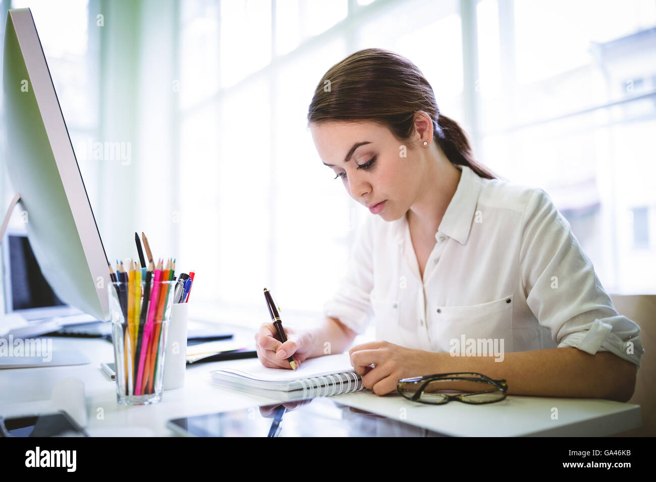 Smart graphic designer writing on document Stock Photo - Alamy