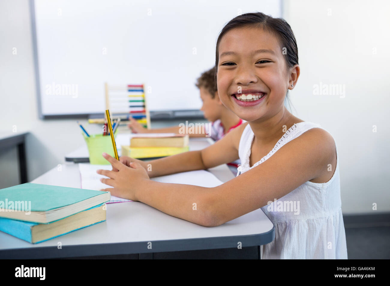 Happy girl studying at desk in in classroom Stock Photo - Alamy