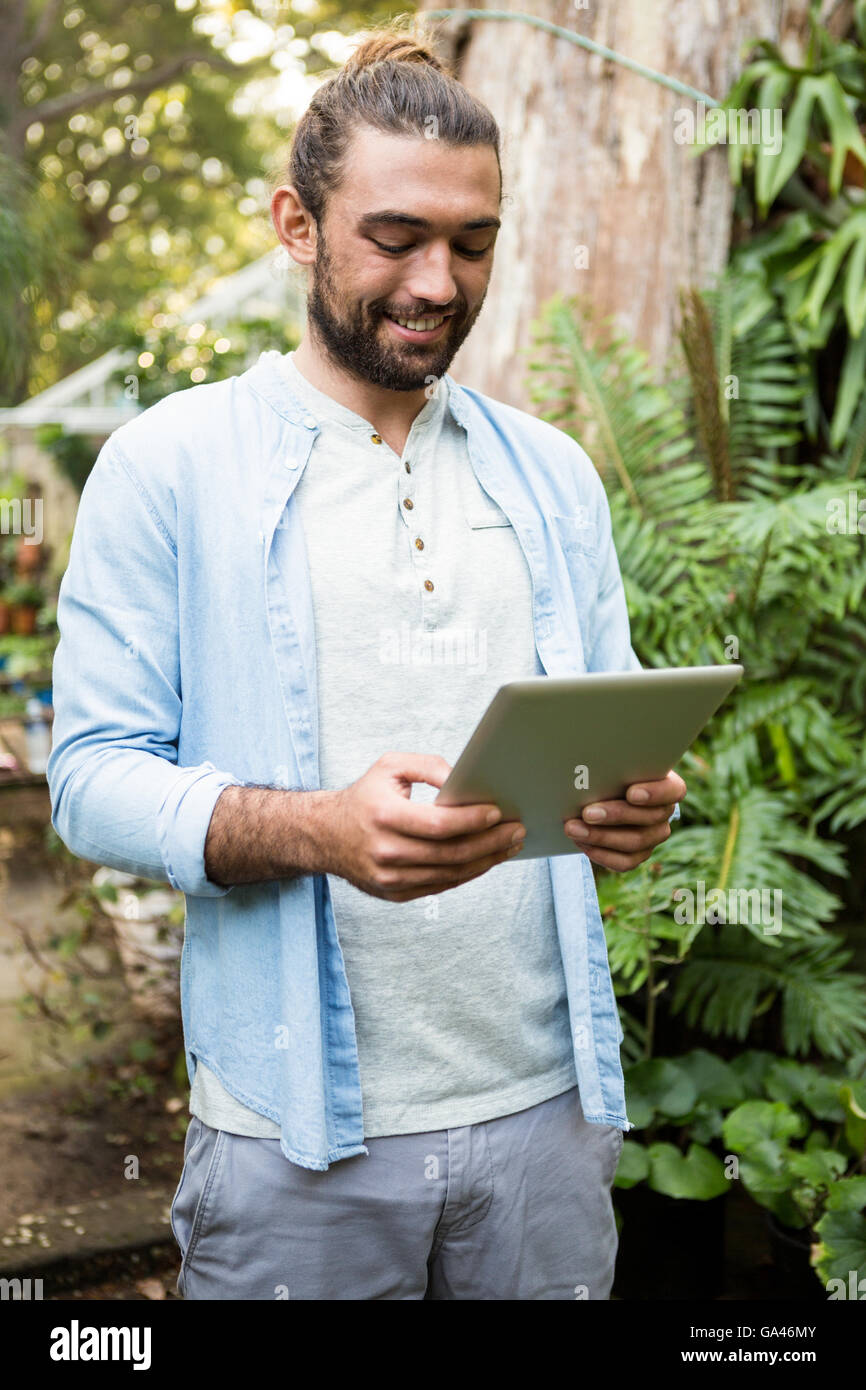 Happy owner using digital tablet at garden Stock Photo - Alamy