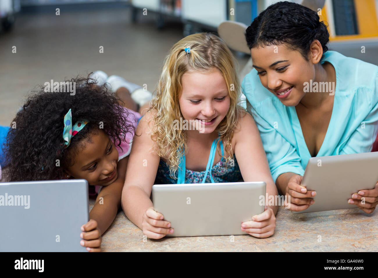 Smiling teacher with girls using digital tablets Stock Photo - Alamy