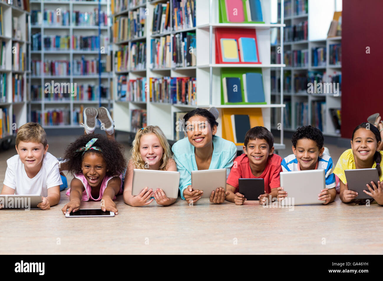 Smiling teacher with students using digital tablets Stock Photo - Alamy