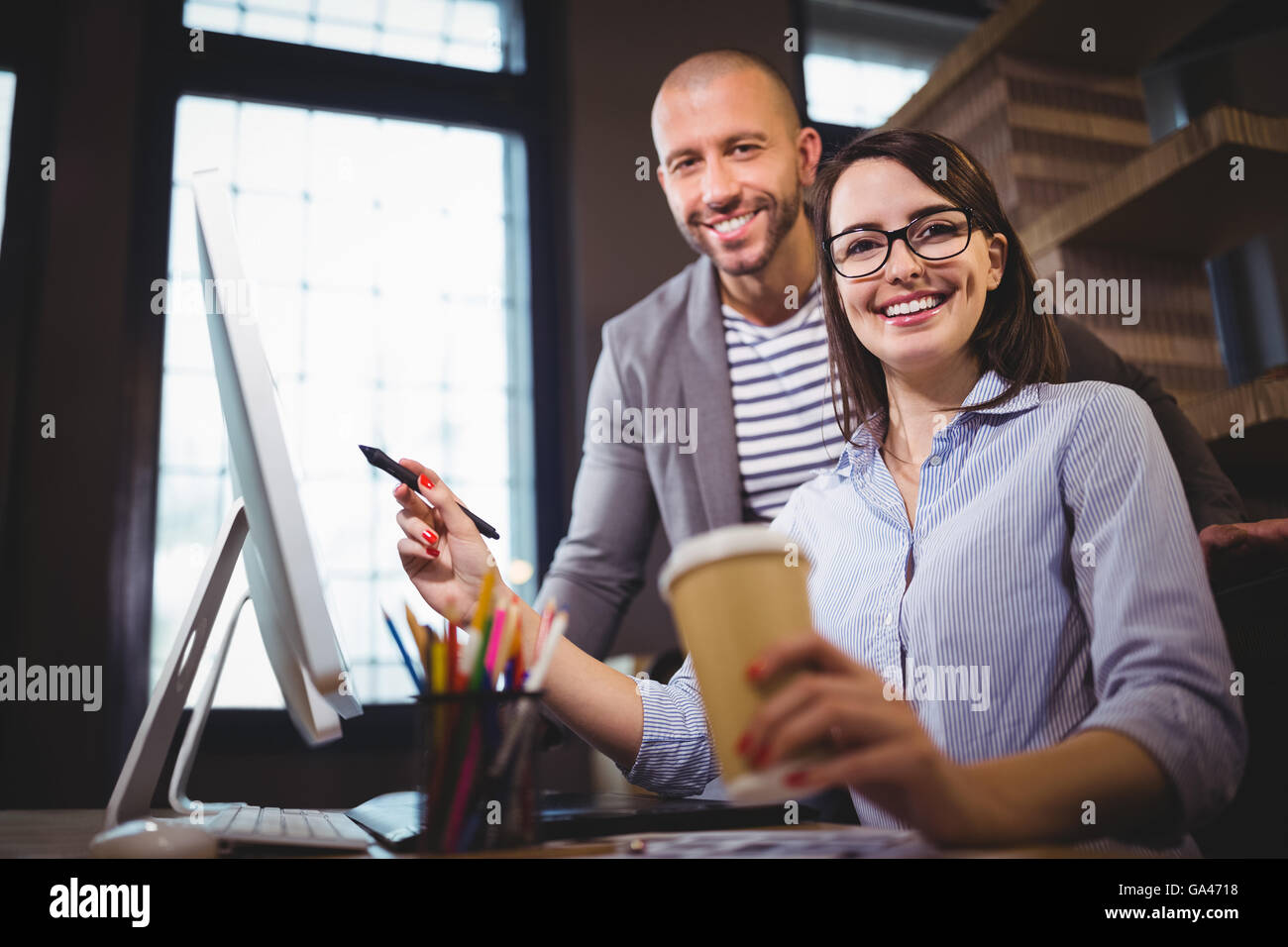 Happy coworkers working at computer desk Stock Photo - Alamy