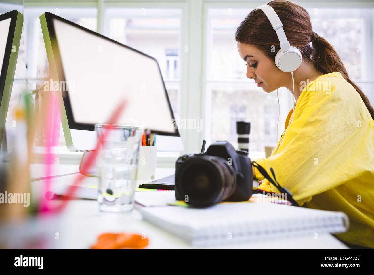 Side view of executive working with camera on desk at creative office ...