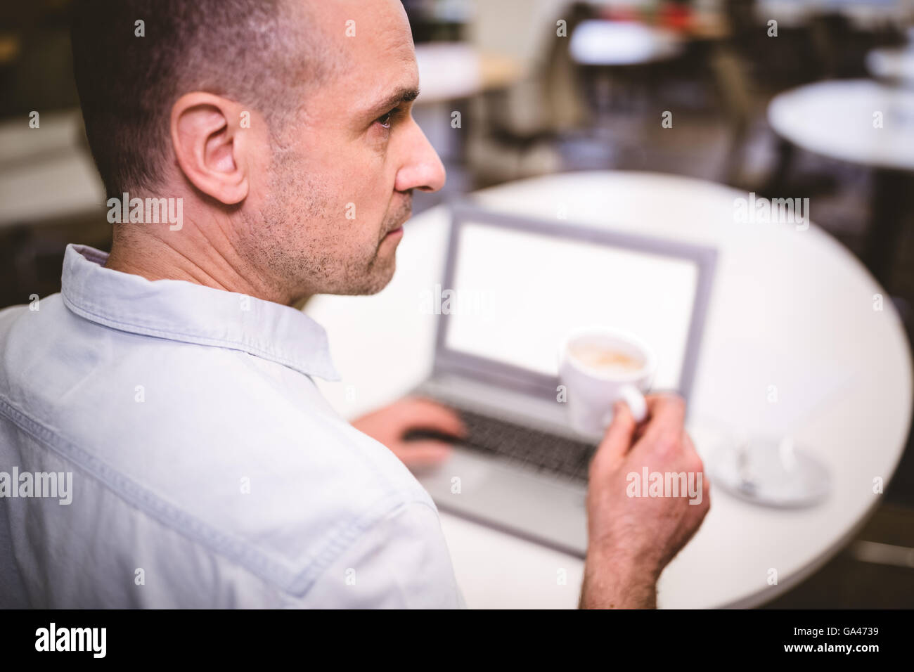 Rear view of businessman drinking coffee at creative office Stock Photo ...