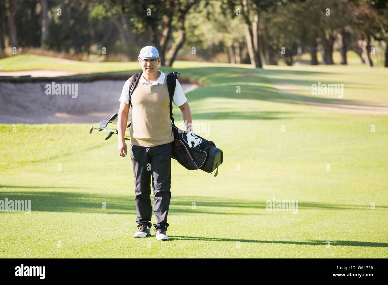Sportsman walking with his golf bag Stock Photo - Alamy