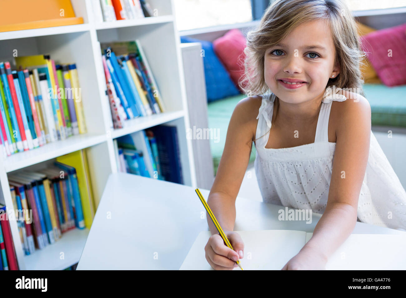 Smiling girl studying in school library Stock Photo - Alamy