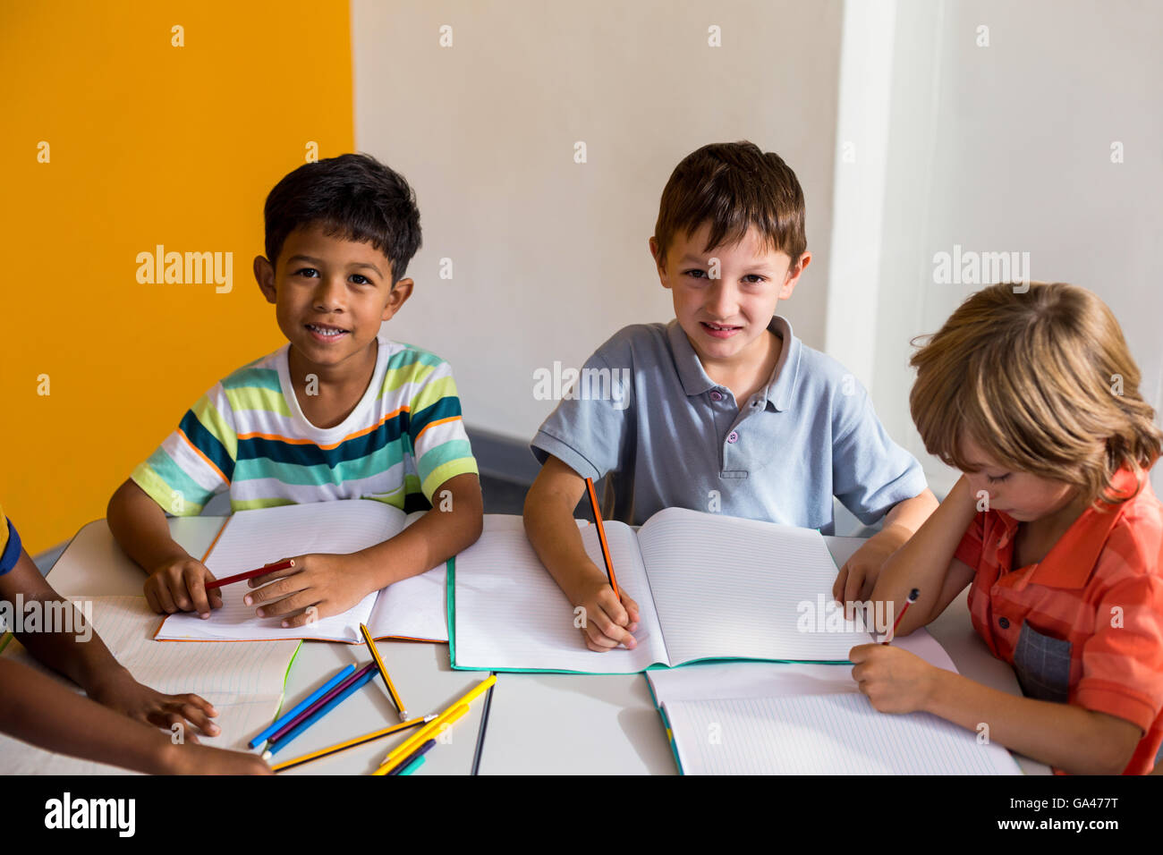 Cute boys with classmates in classroom Stock Photo - Alamy