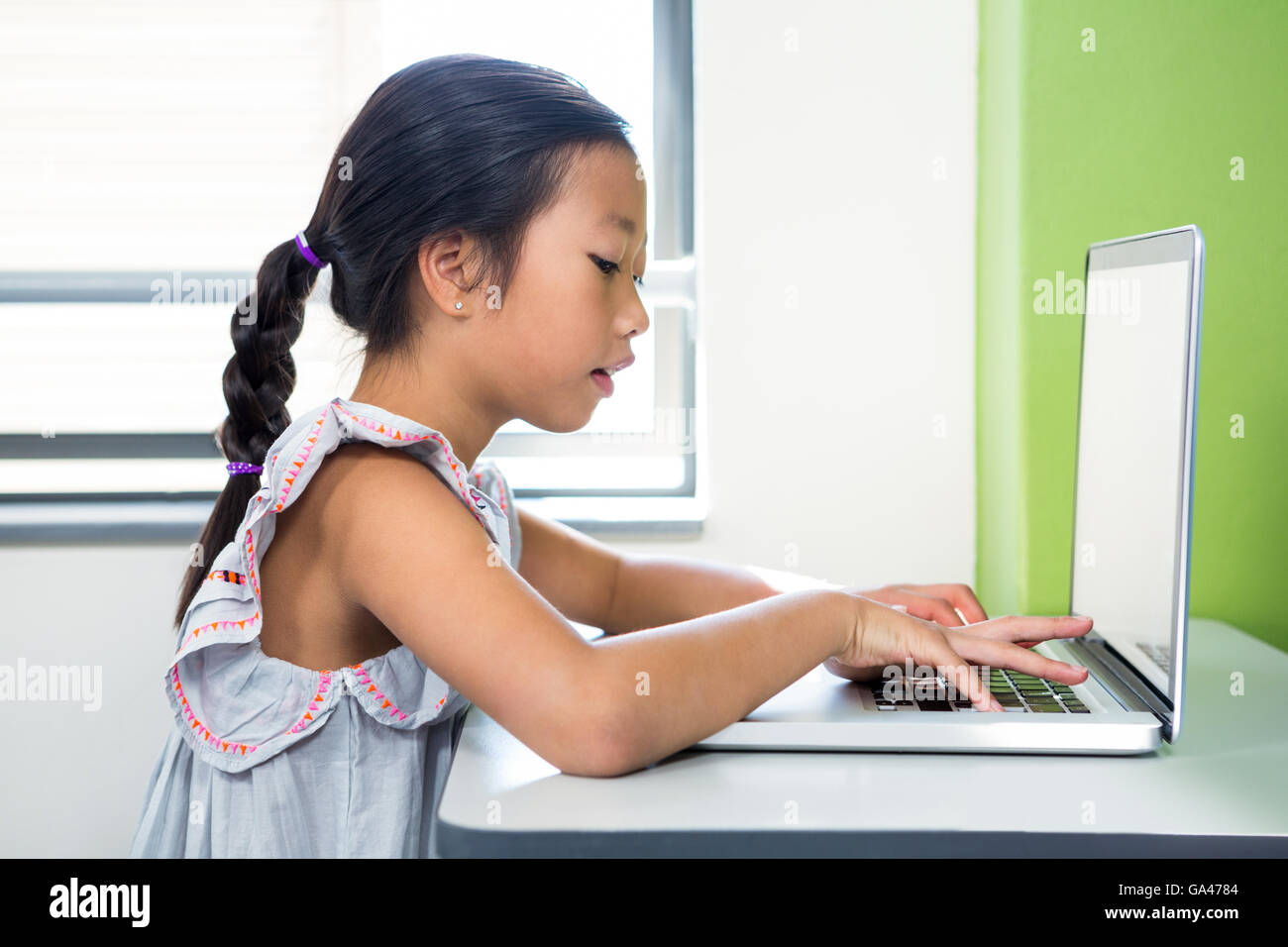 Girl using laptop in classroom Stock Photo - Alamy