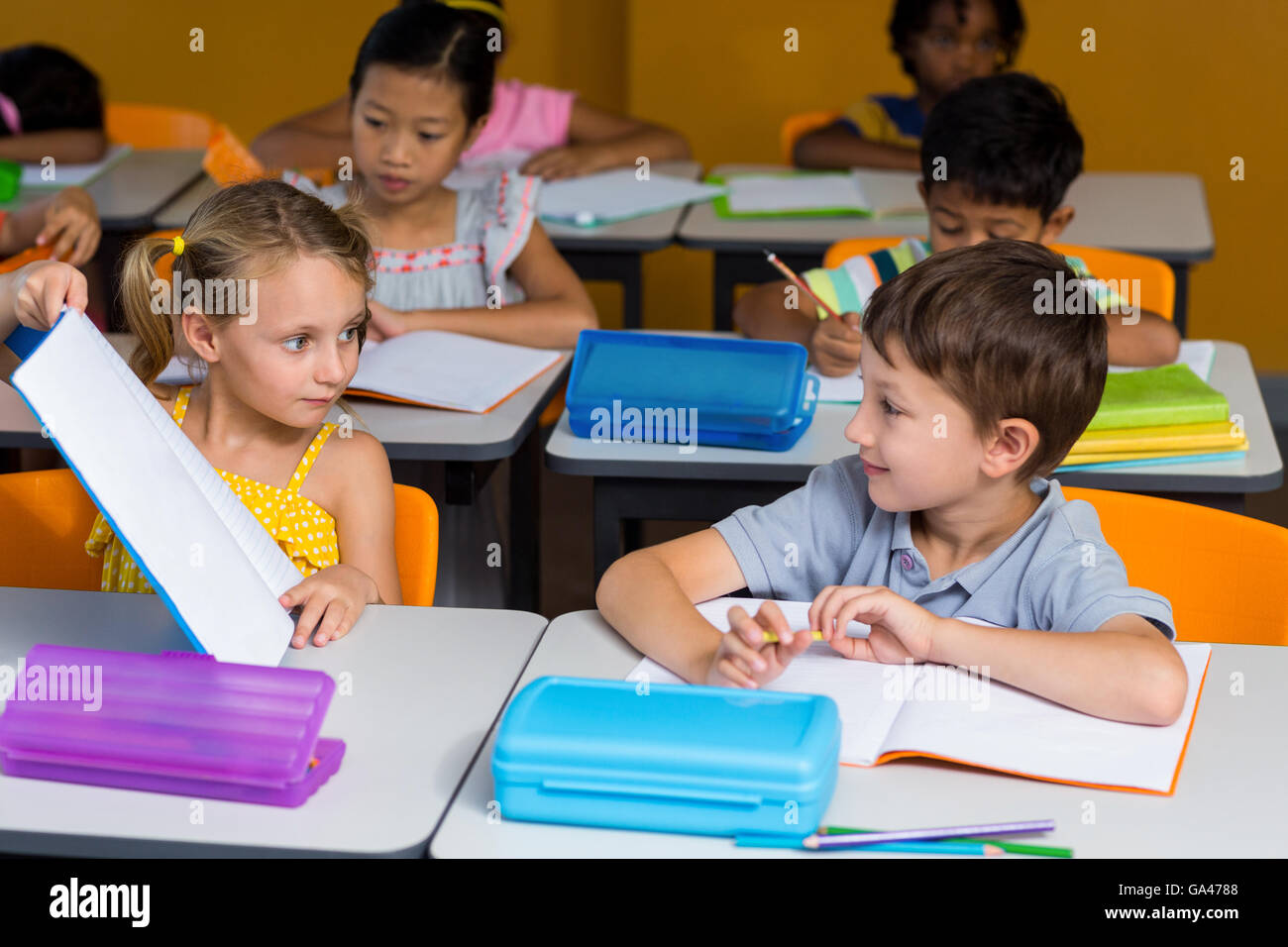 Girl showing book to classmate Stock Photo - Alamy