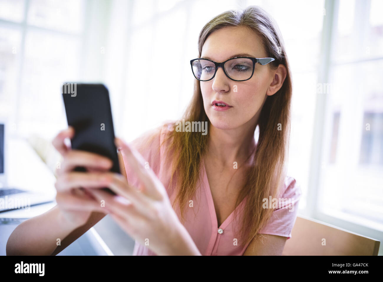 Attractive graphic designer using phone Stock Photo - Alamy