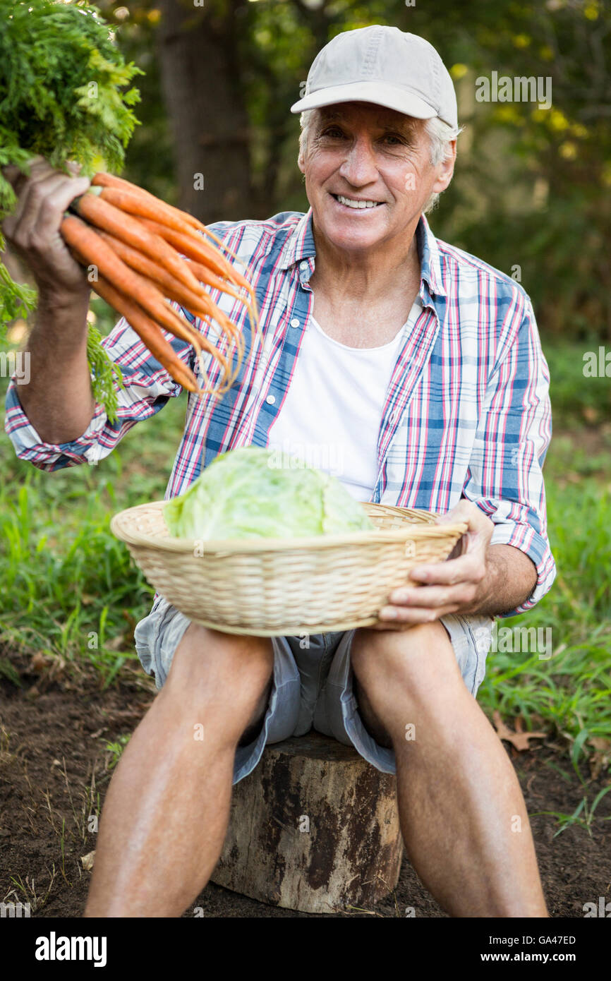 Portrait of man with carrots and cabbage at garden Stock Photo - Alamy