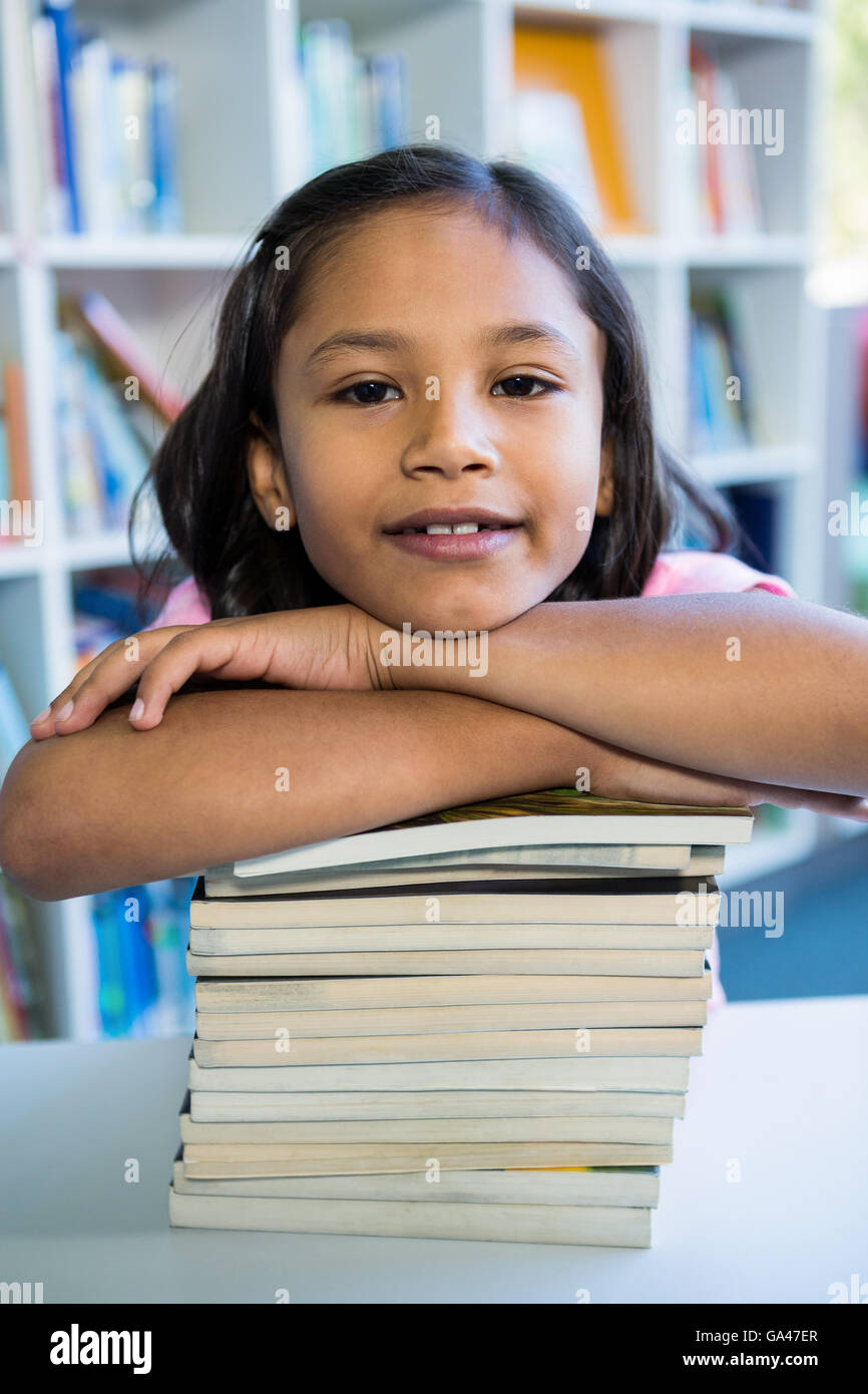 Girl leaning on books at table in school library Stock Photo - Alamy