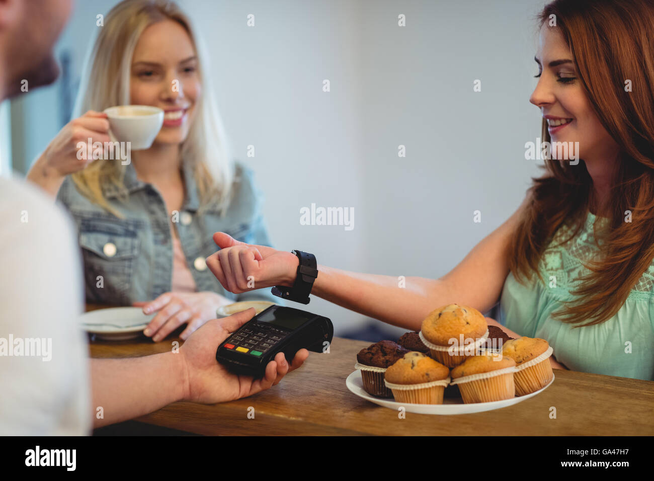 Happy customer with smart watch paying at cafe Stock Photo - Alamy