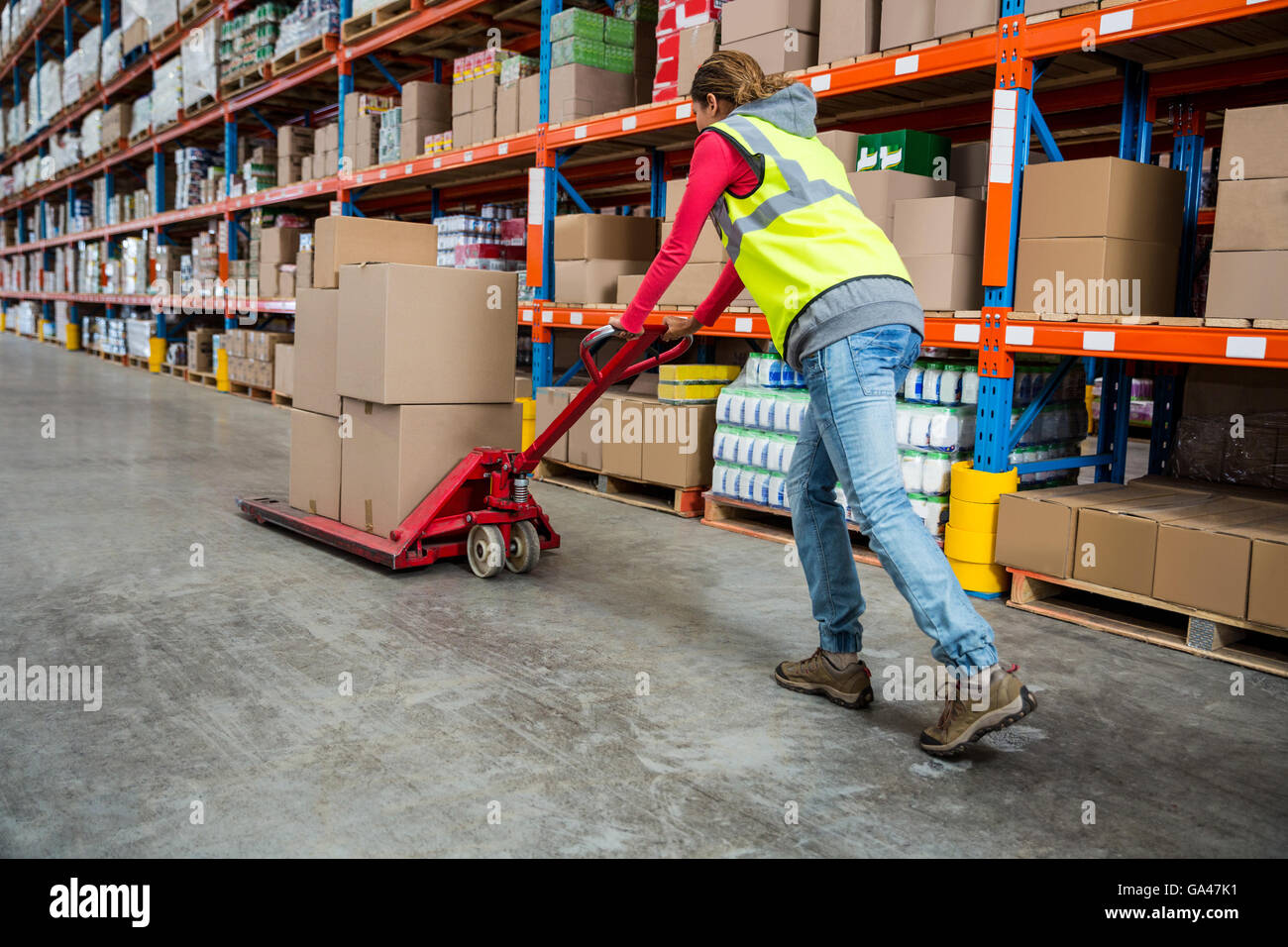 Worker pushing trolley with boxes Stock Photo - Alamy
