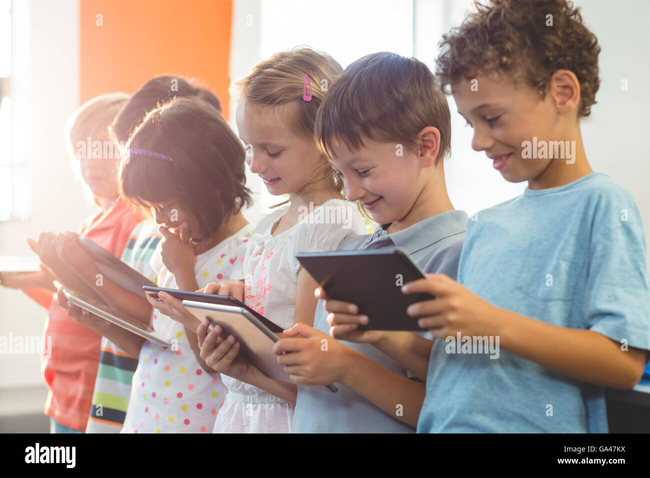 Smiling children using digital tablets Stock Photo - Alamy