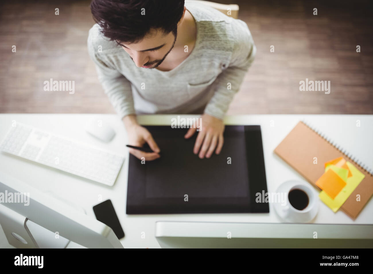 Businessman using graphics tablet in creative office Stock Photo - Alamy