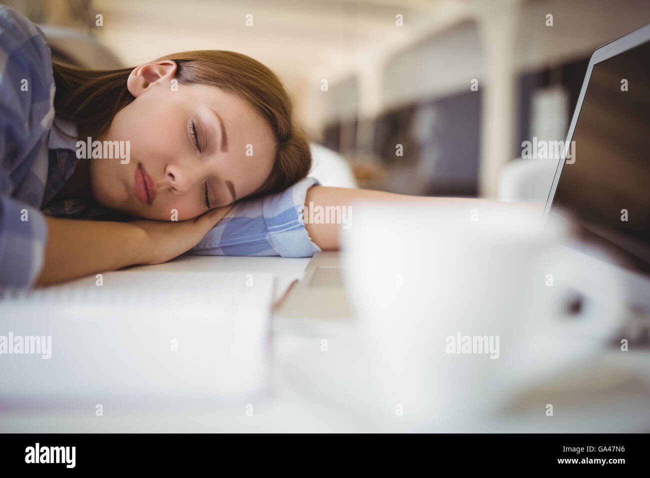 Tired businesswoman taking nap on desk in creative office Stock Photo ...