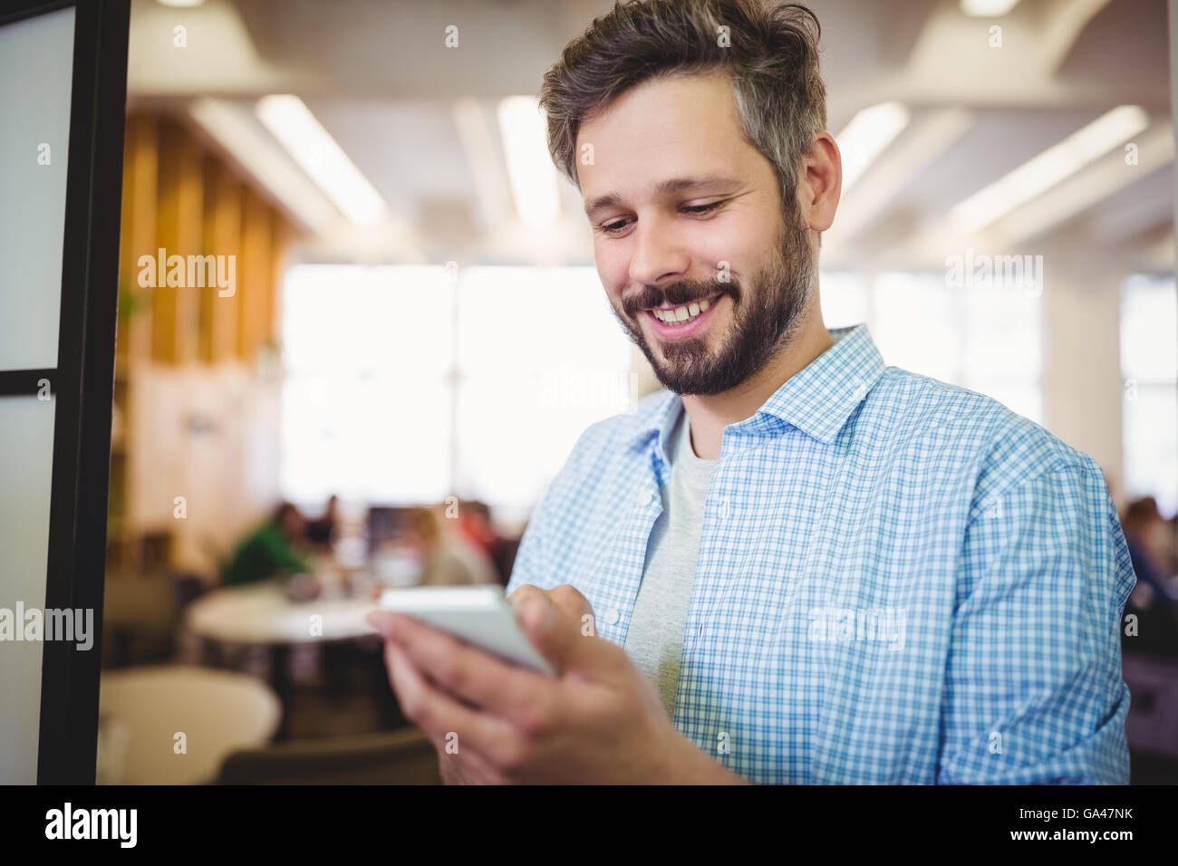 Happy businessman using phone in cafeteria Stock Photo - Alamy