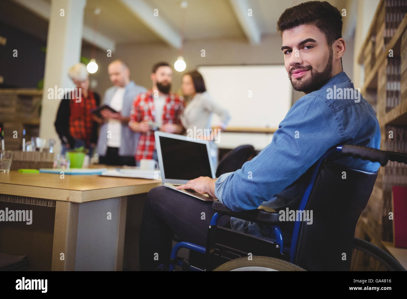 Smart disabled businessman using laptop at desk Stock Photo - Alamy
