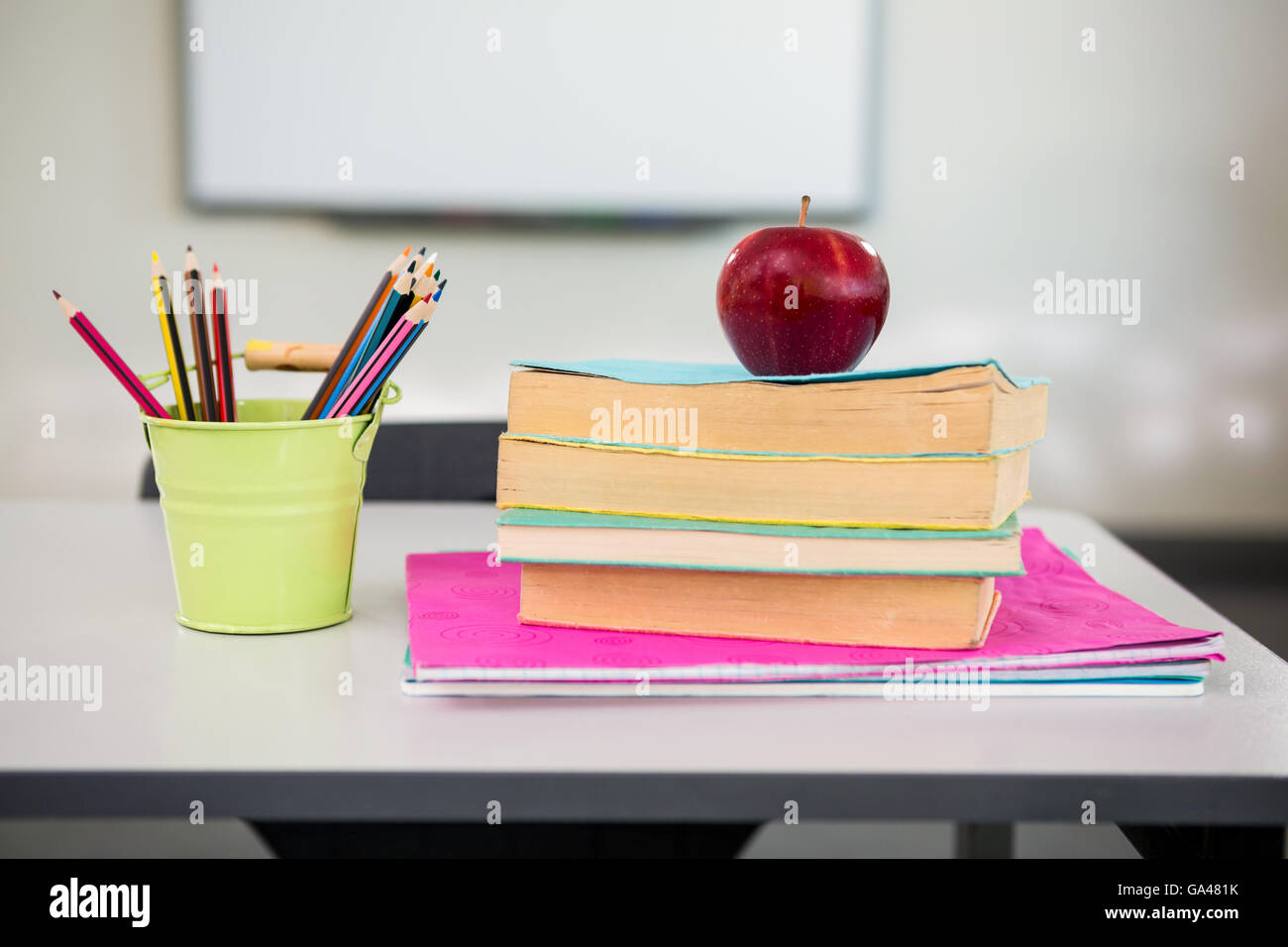 Apple with books and desk organizer on table in classroom Stock Photo ...